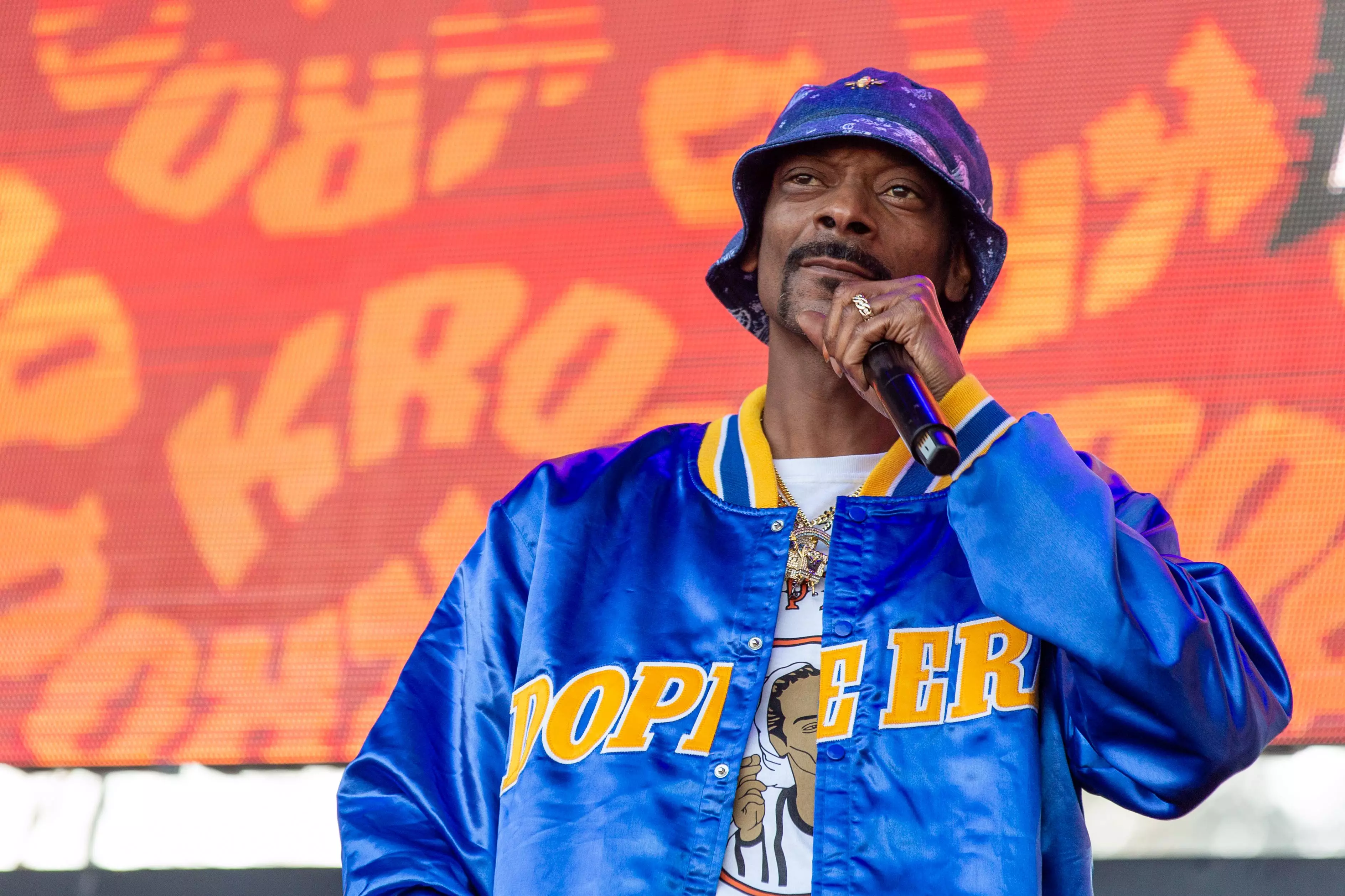 Snoop Dogg na jaket na-acha anụnụ anụnụ na okpu na-acha anụnụ anụnụ n'oge arụmọrụ 2019