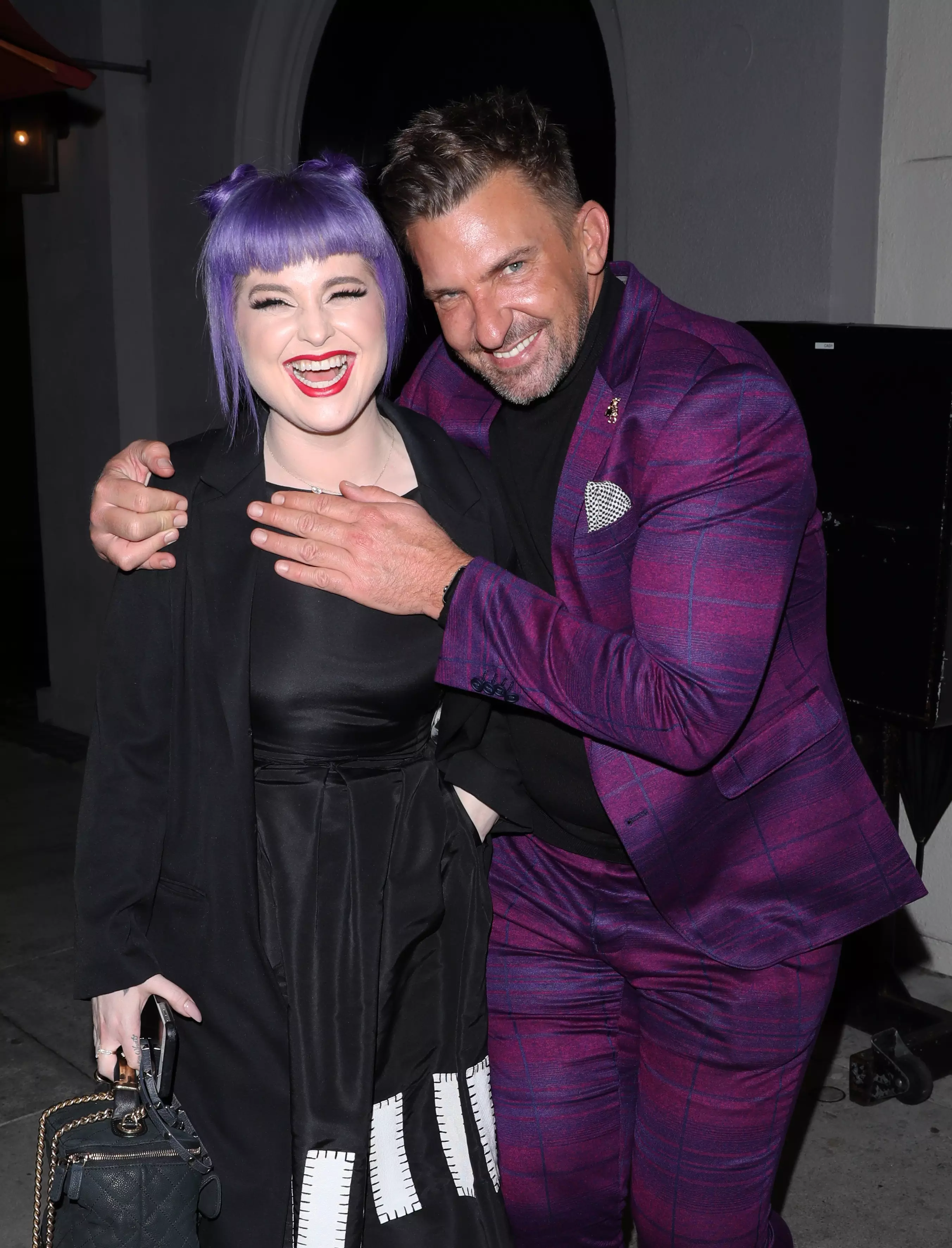 Kelly Osbourne šypsosi, o jos draugas vakarieniauja Los Andželo restorane „Craig's“.