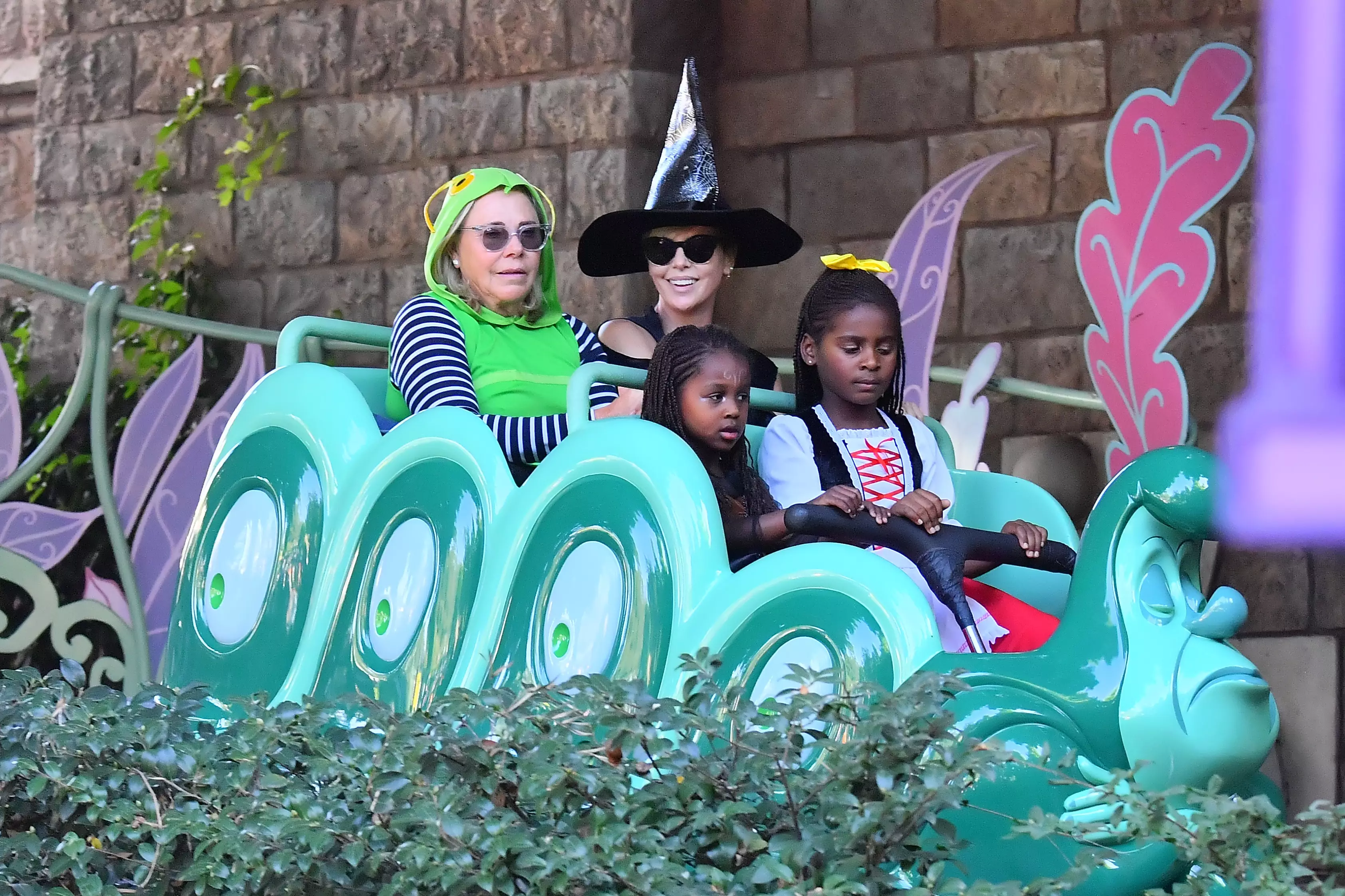 Charlize Theron entra nello spirito di Halloween mentre si dirige a Disneyland in un costume da strega con i suoi figli e la madre