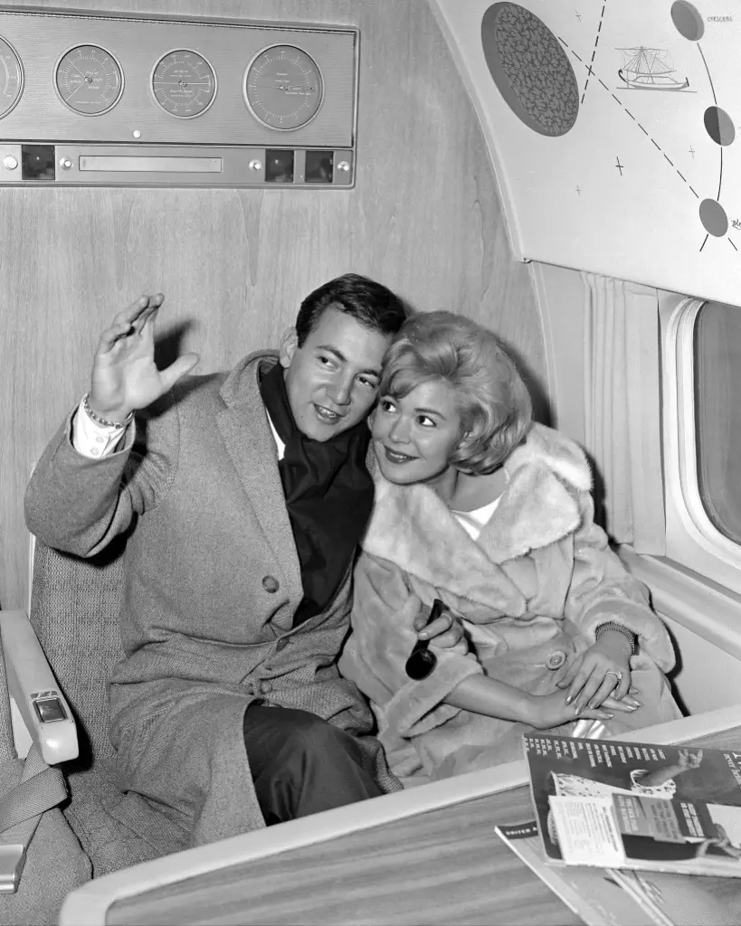 Bobby Darin, de 24 anys, el jove amb els tons oscil·lants, s'abraça a la seva núvia, l'actriu Sandra Dee, de 18 anys, mentre volen sortir de l'aeroport internacional per a la lluna de mel de Hollywood.