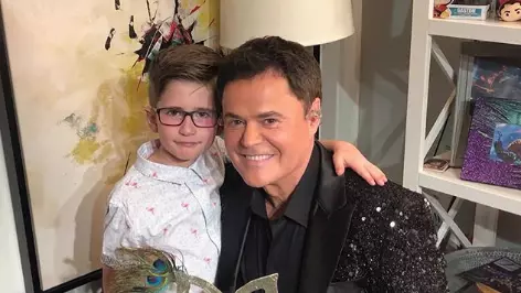 Ο μασκοφόρος τραγουδιστής Donny Osmond παίρνει το τρόπαιο από τον θαυμαστή μετά τη 2η θέση