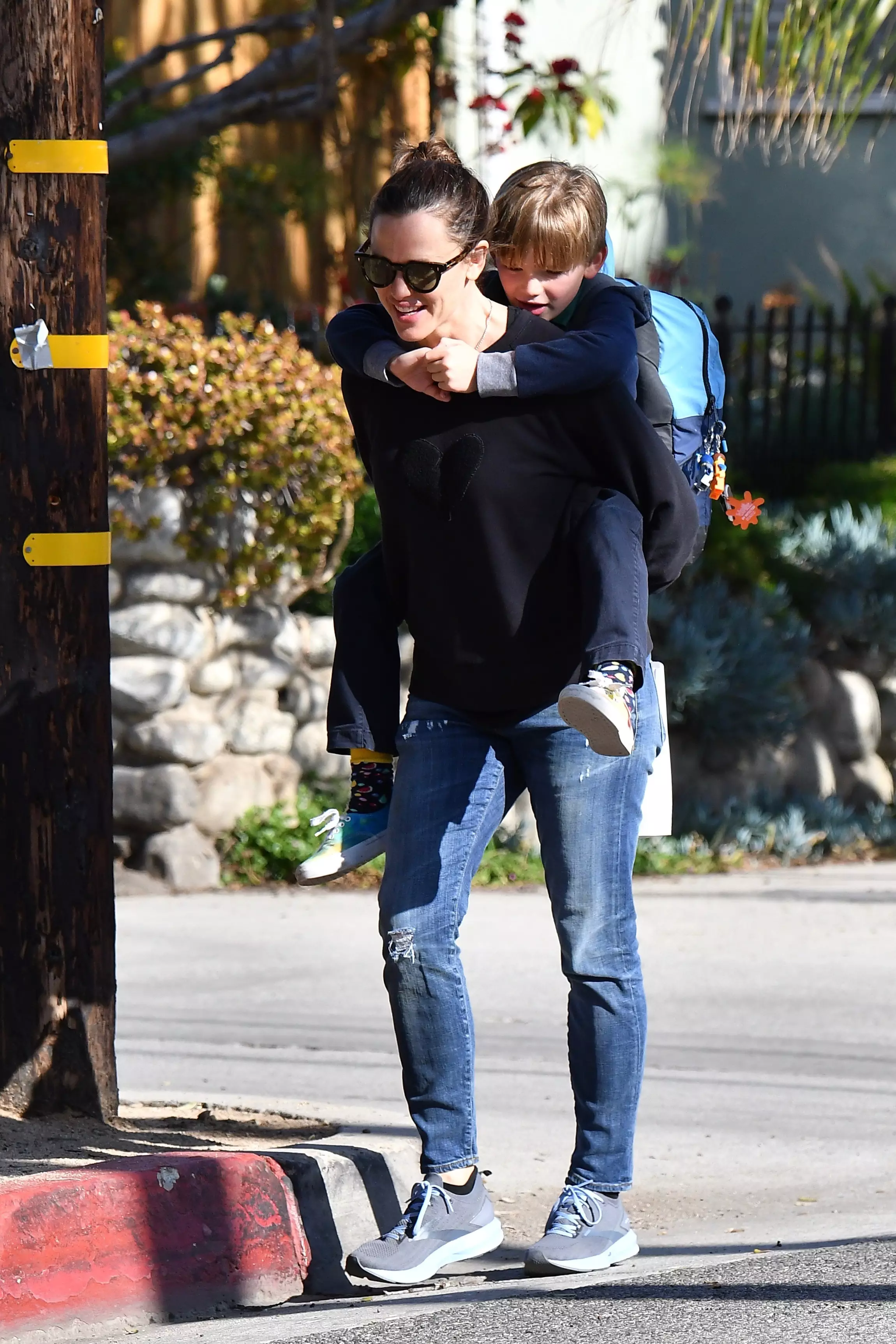 Mae Jennifer Garner yn rhoi reid mochyn i'w mab ar ôl ei godi o'r ysgol.